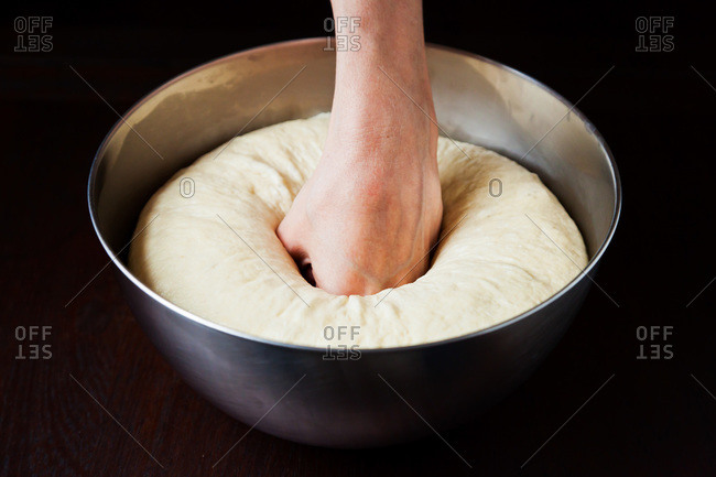 Mixing bread dough by hand Punching down the dough stock photo - OFFSET