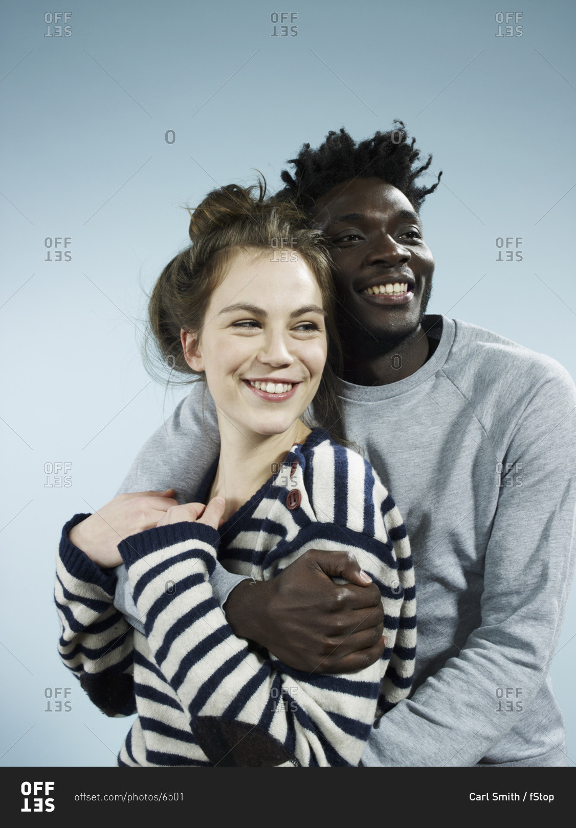 A Smiling Young Man Embracing His Smiling Girlfriend From Behind Stock