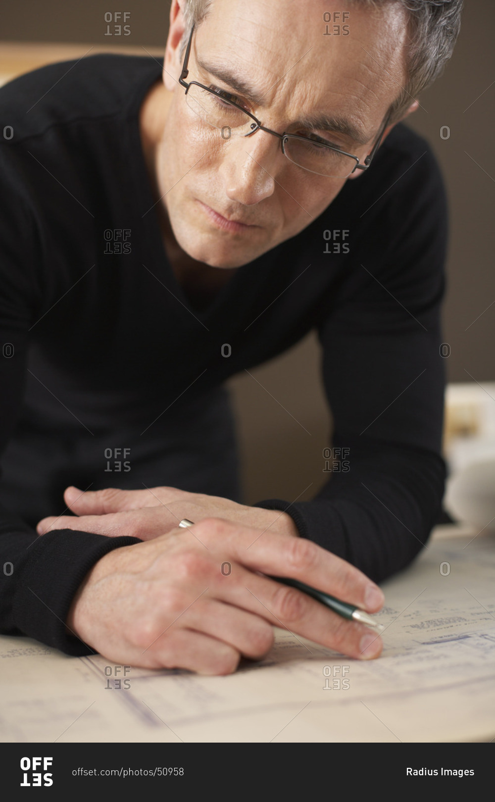 Portrait of man with blueprints stock photo - OFFSET
