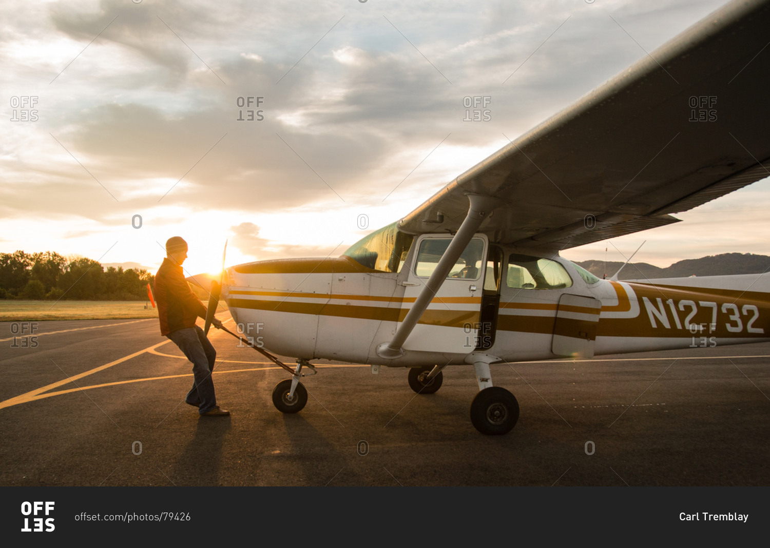 Side view of a man pulling a light aircraft stock photo - OFFSET