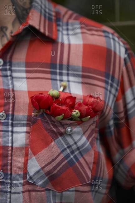 Close up of a man with red flowers in his pocket - Stock Image - Everypixel
