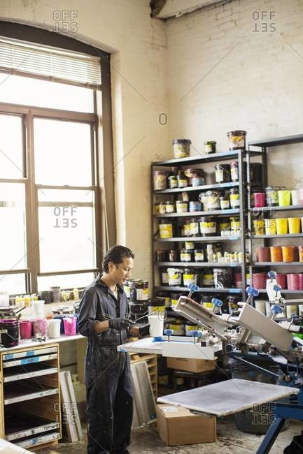 Young Asian man working with screen printing carousel - Stock Image ...