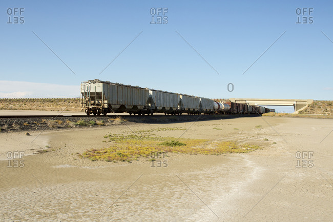 Freight train cars on rails in a desert landscape - Stock Image ...
