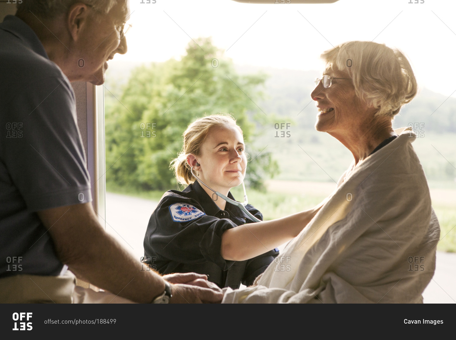 Paramedic assisting elderly woman in an ambulance stock photo - OFFSET