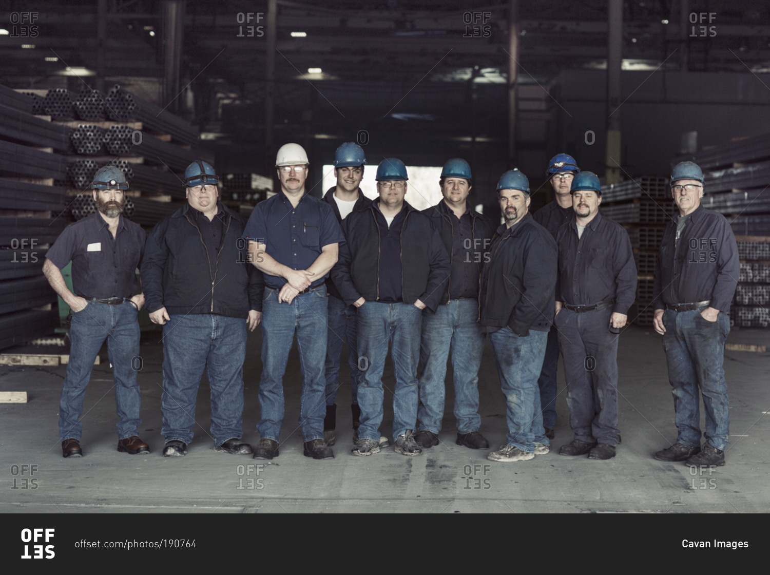 Group of factory workers standing together stock photo - OFFSET