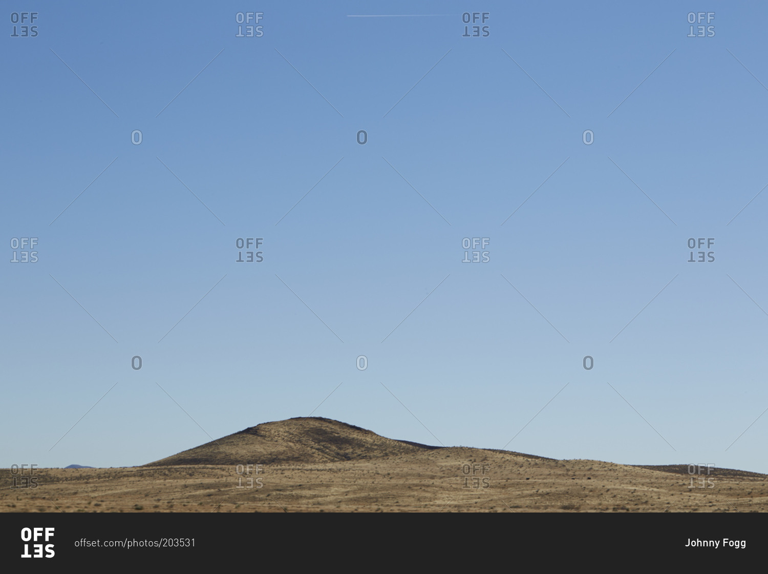 A small hill in a flat field stock photo - OFFSET