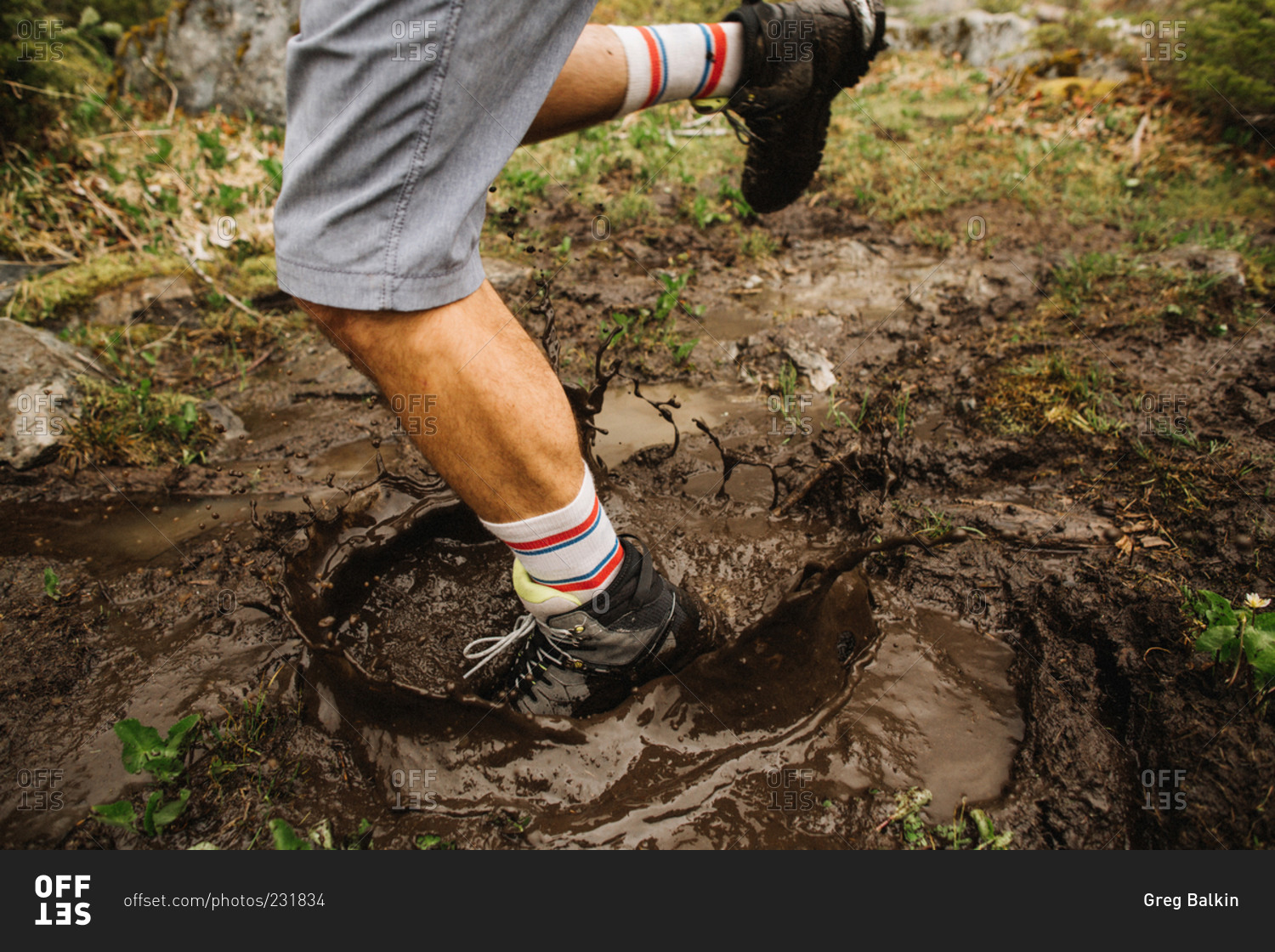 Hiker's feet splashing through mud - Stock Image - Everypixel