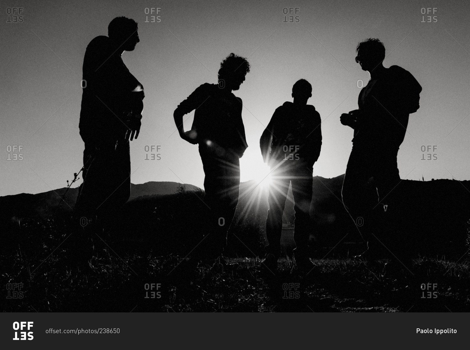Four men in silhouette in the mountains at sunset - Stock Image - Everypixel
