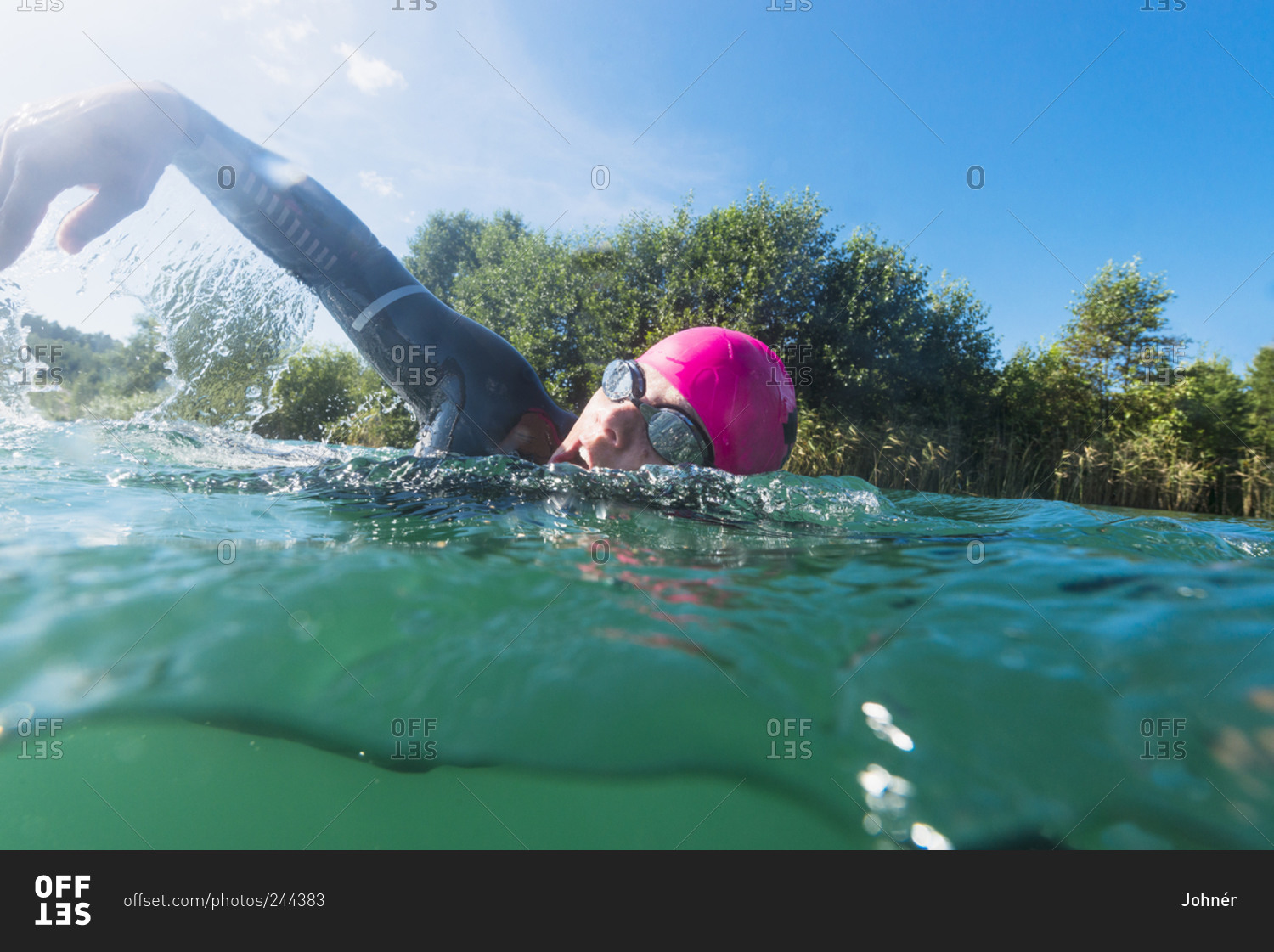 Man swimming in pink cap stock photo - OFFSET