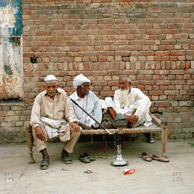 Lahore, Pakistan - March 1, 2009: Three Pakistani men sharing a hookah ...