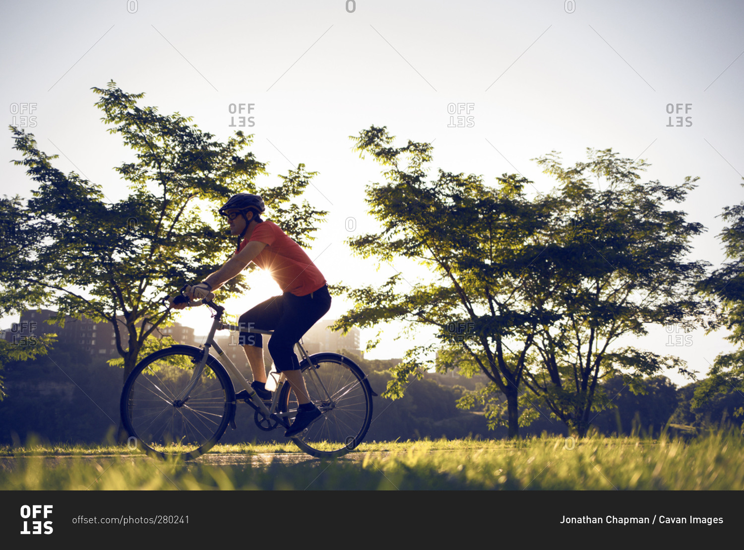Man riding his bike through a park - Stock Image - Everypixel