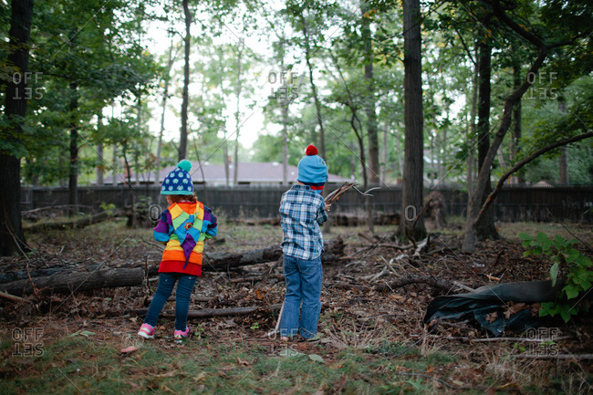 Two small children gathering sticks stock photo - OFFSET