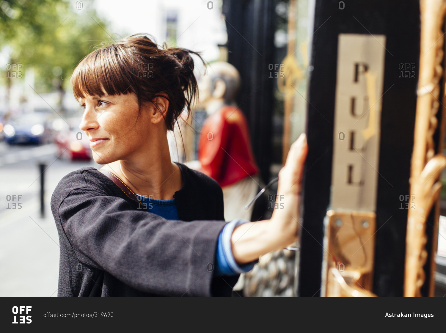 Woman looking back opening door stock photo - OFFSET