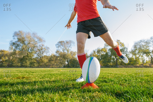 Powerful man kicking the ball for a goal on rugby field stock photo ...