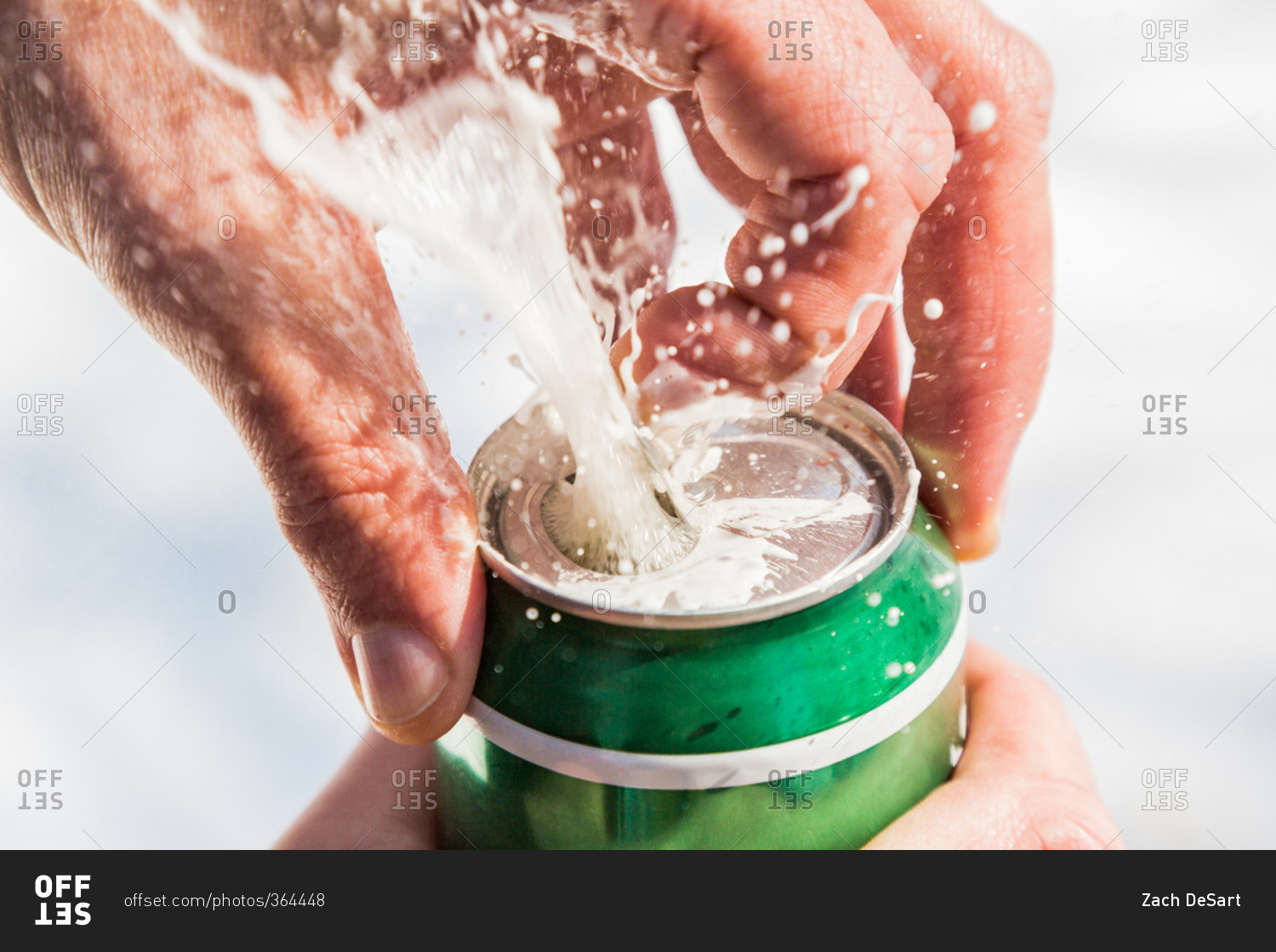 Close-up of liquid exploding from a can being opened under pressure ...