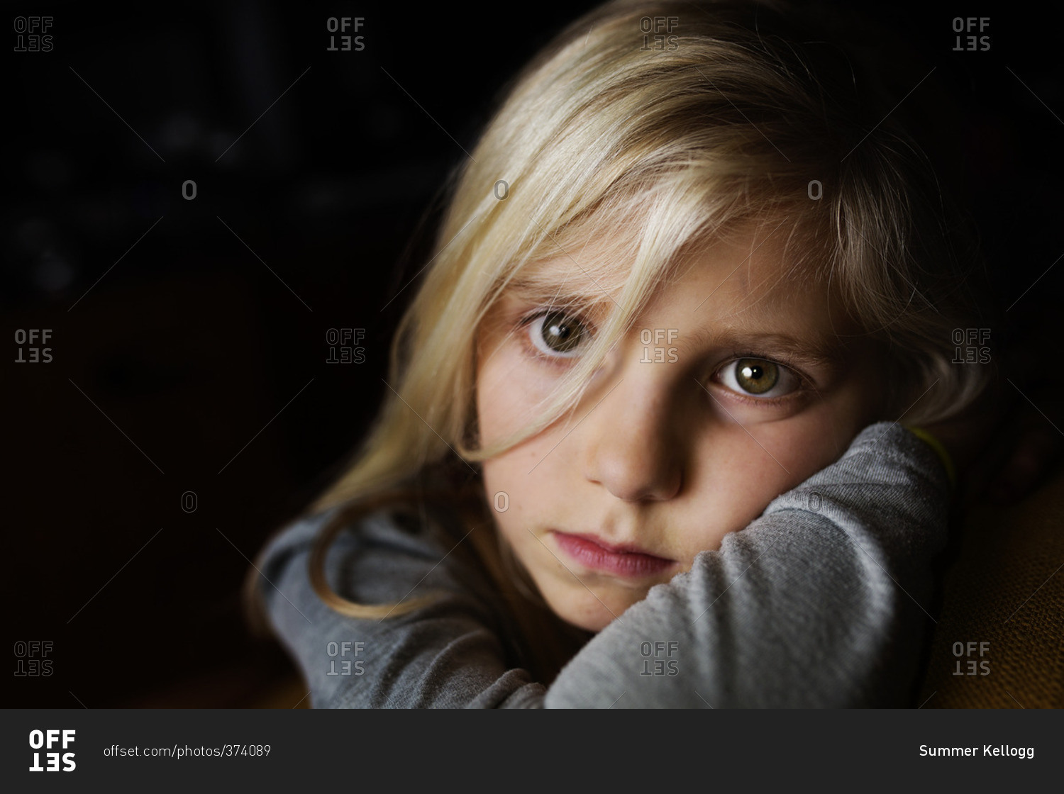 Close up of a sad little blonde girl stock photo - OFFSET