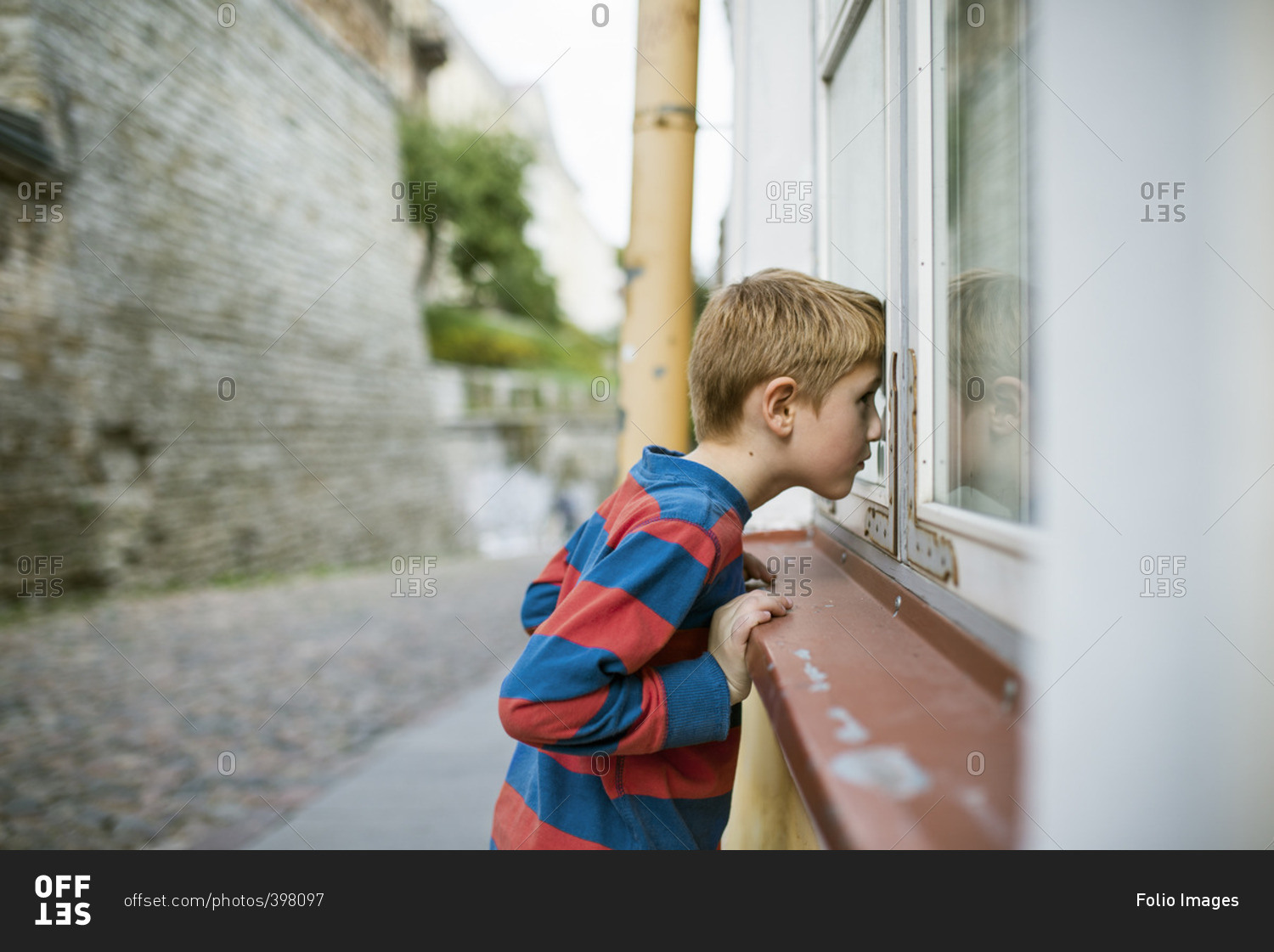 Estonia, Tallinn, Boy looking into house through window stock photo ...