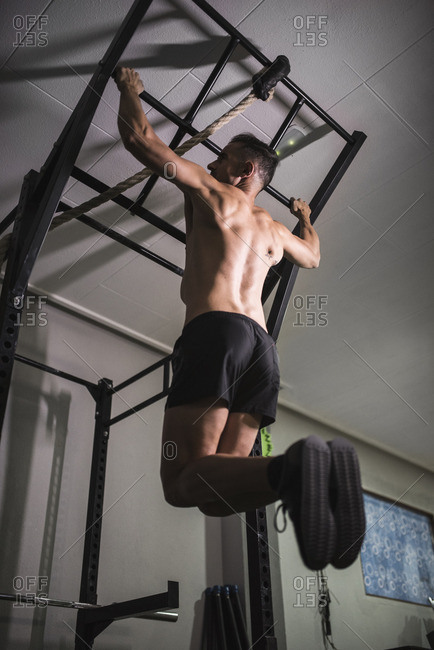 Man doing chin-ups at power rack - Stock Image - Everypixel