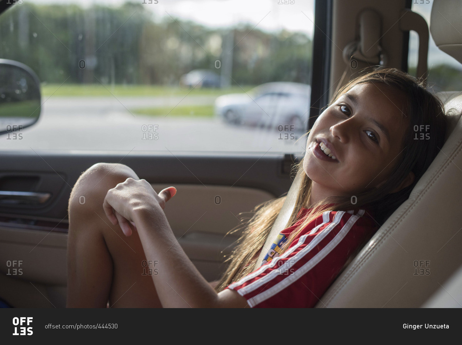 Young girl lounging in car seat stock photo - OFFSET