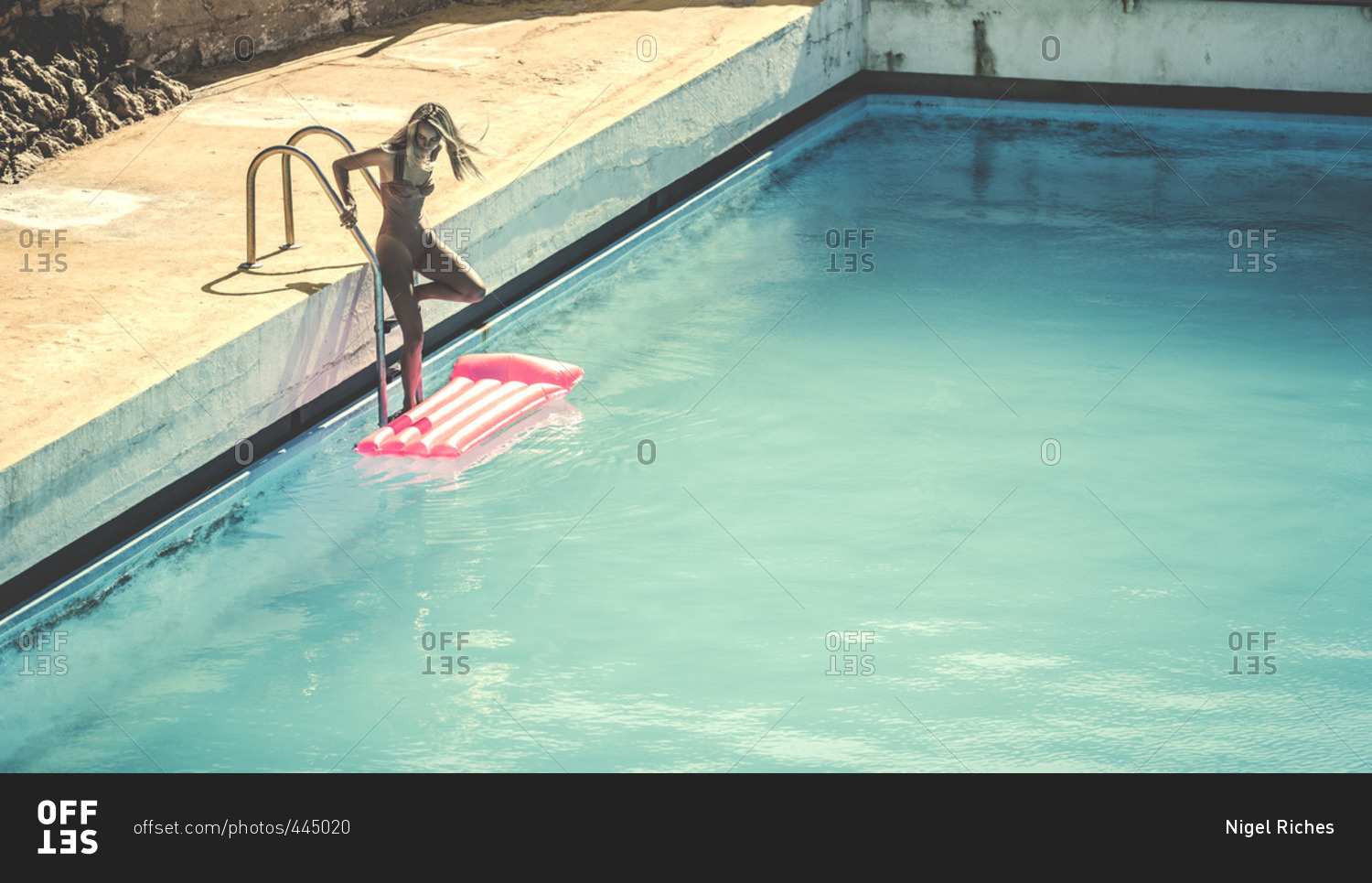Woman stepping onto an inflatable raft in a swimming pool - Stock Image ...