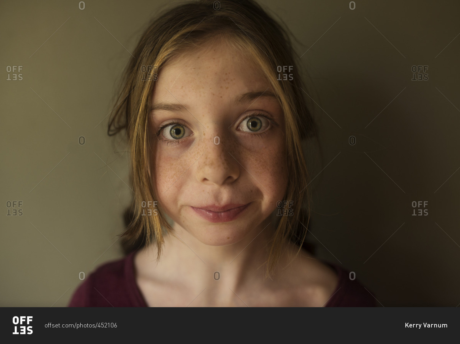 Portrait of a wide-eyed girl with freckles stock photo - OFFSET