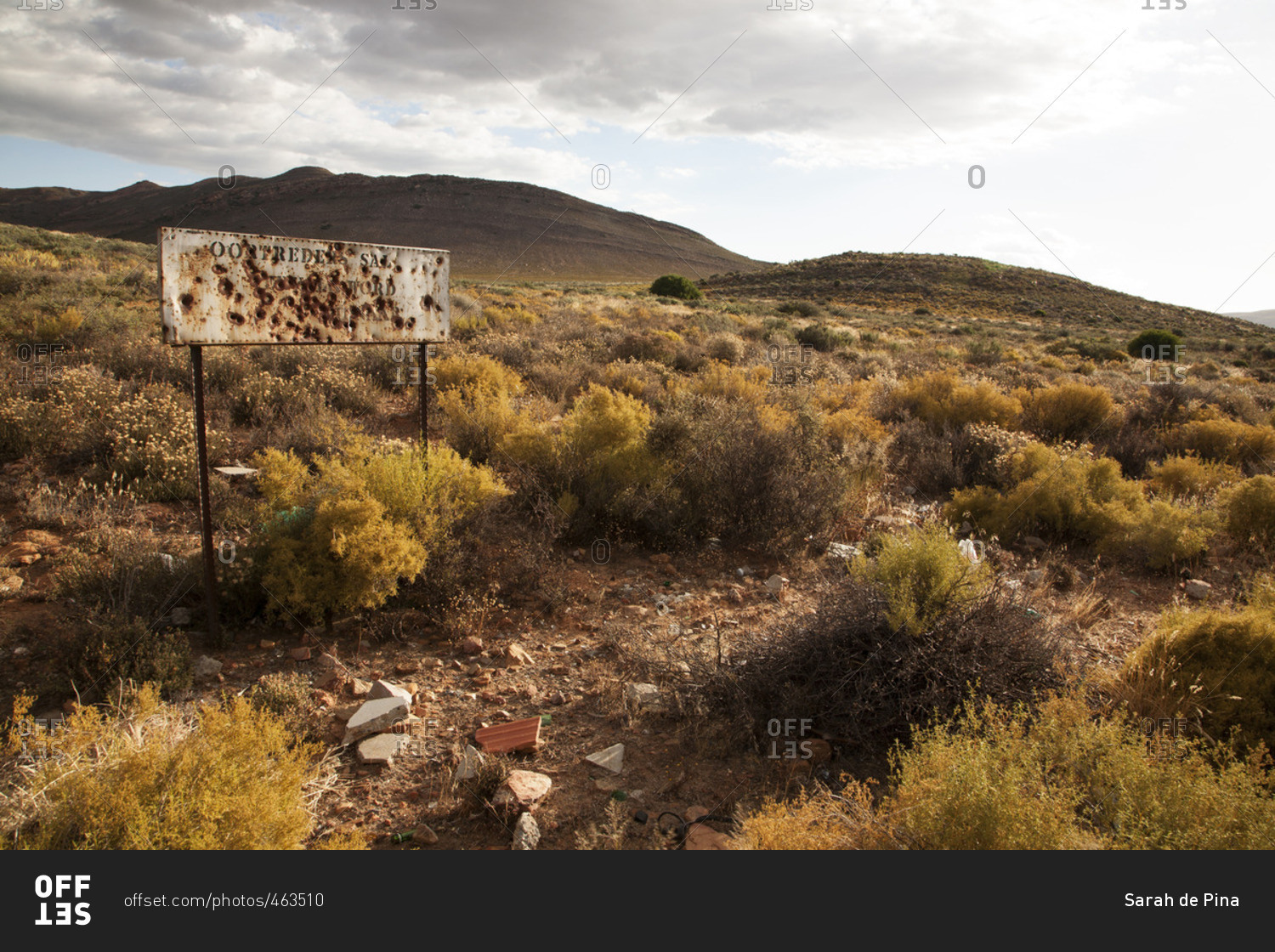 Wasteland landscape with broken sign and distant mountains stock photo ...