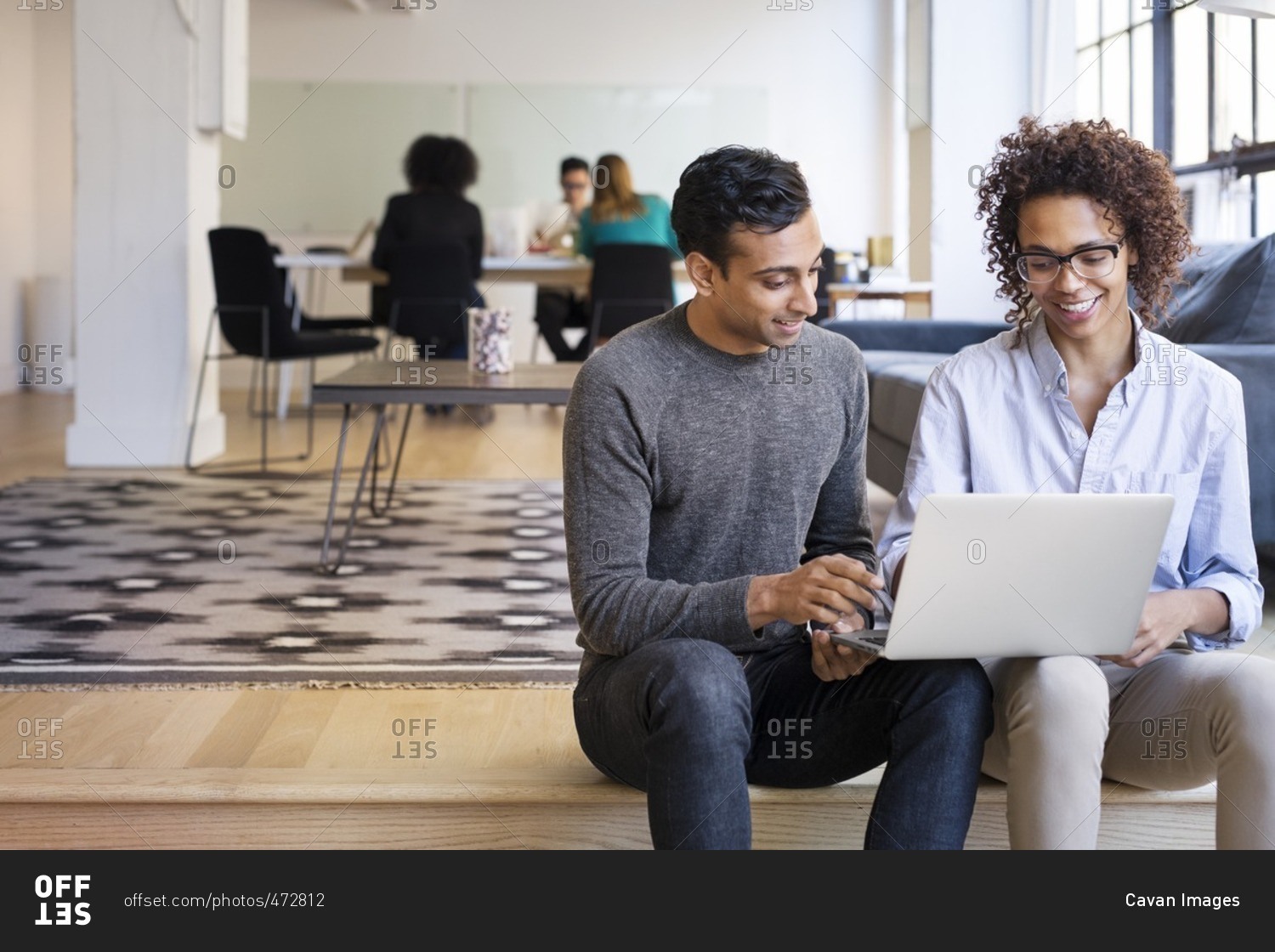 Business people using laptop computer while colleagues working in ...