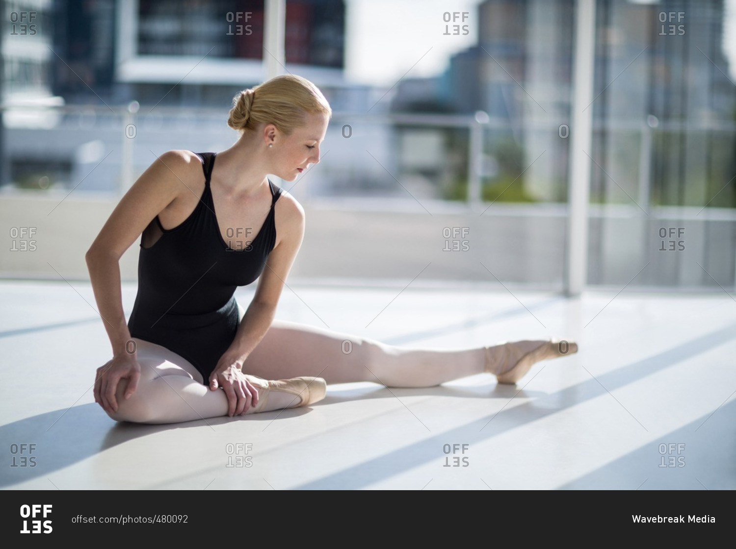 Ballerina performing a split in the ballet studio stock photo - OFFSET