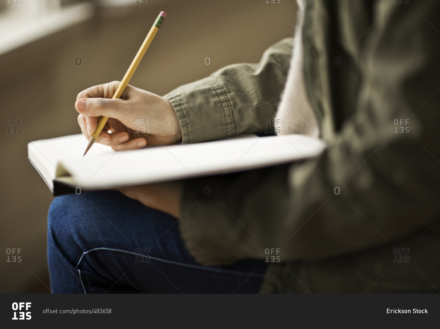 Person writing in a book stock photo - OFFSET