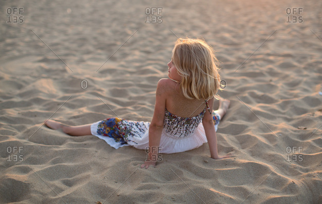 Little girl lying on the sand at beach stock photo - OFFSET Little girl lying on the sand at beach stock photo - OFFSET