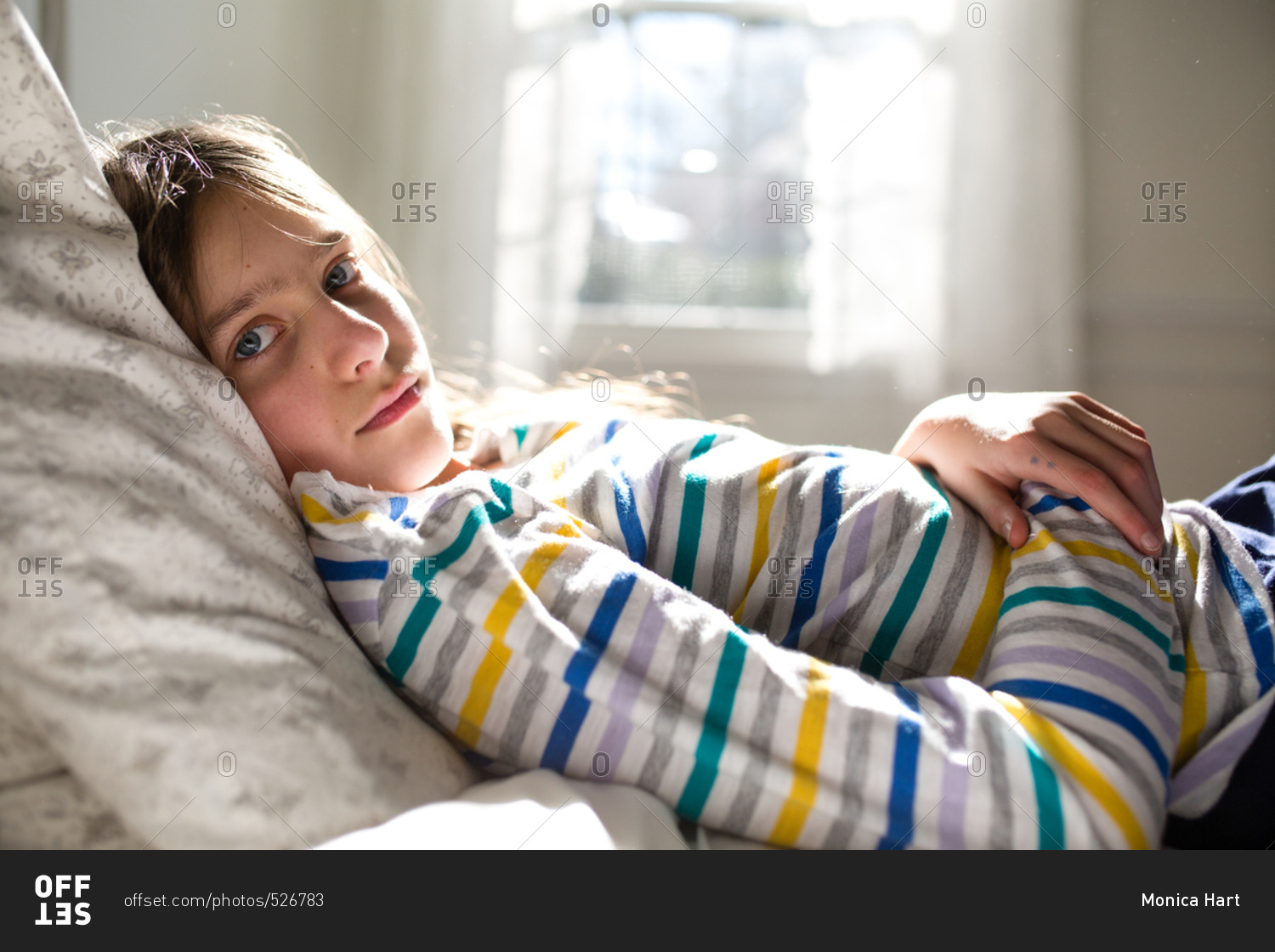 Tween girl lying in bed stock photo - OFFSET