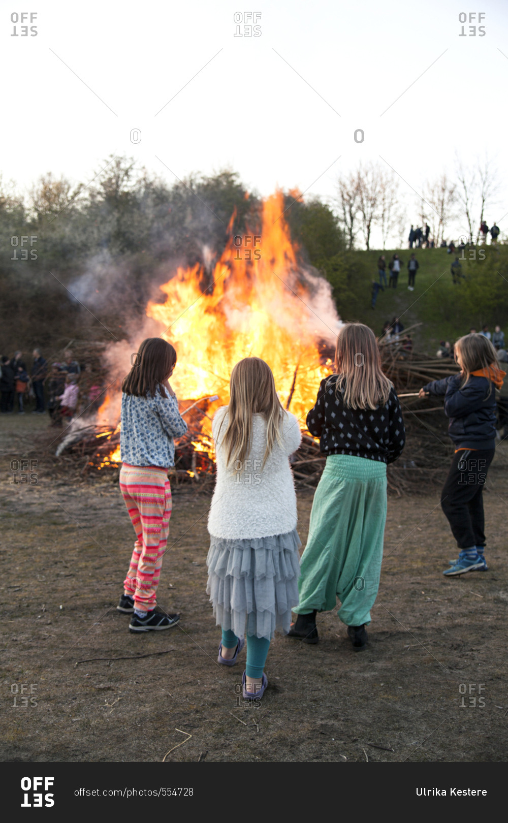Four girls by a fire outside - Stock Image - Everypixel