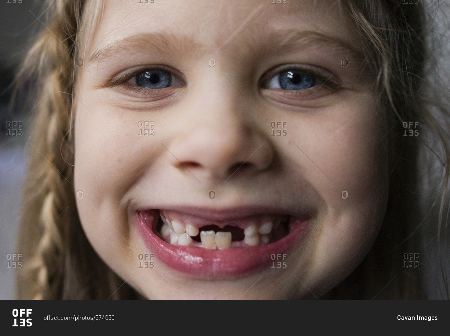 Close-up portrait of happy girl showing teeth stock photo - OFFSET
