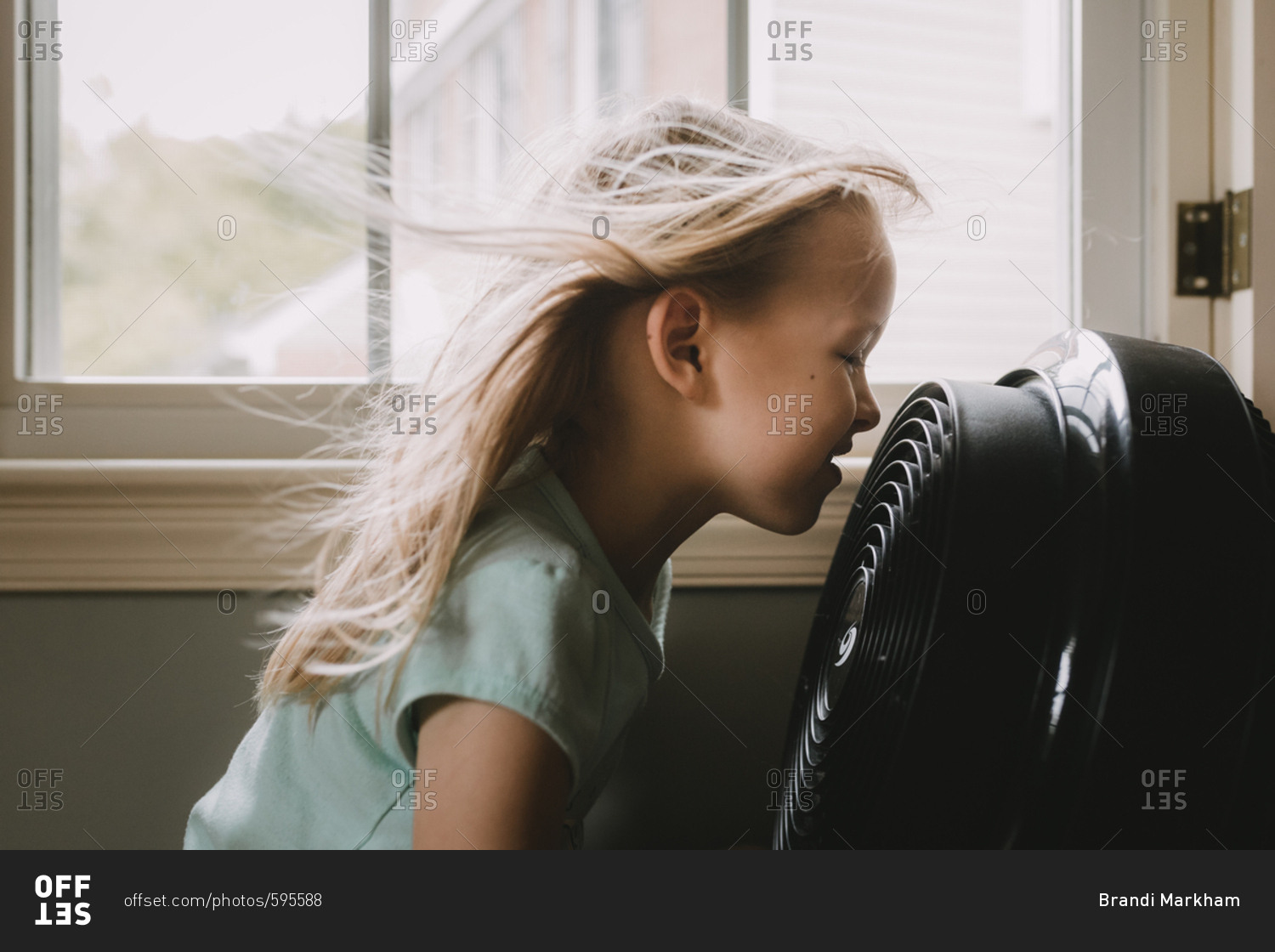 Girl talking into fan - Offset stock photo - OFFSET