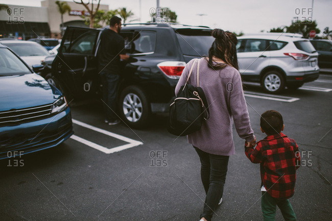 Mother and son walking in parking lot stock photo - OFFSET