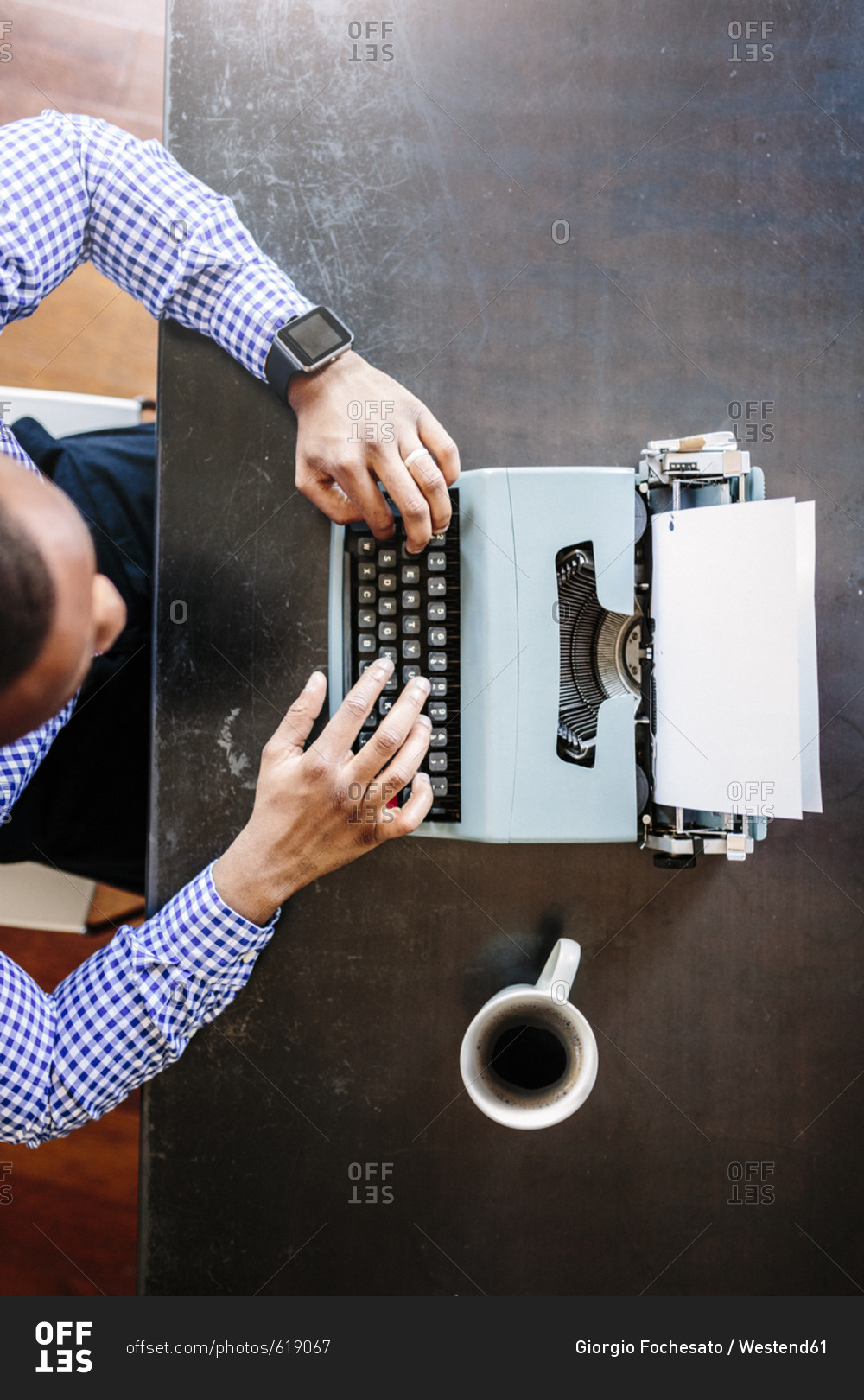 Young man at desk using typewriter - Stock Image - Everypixel