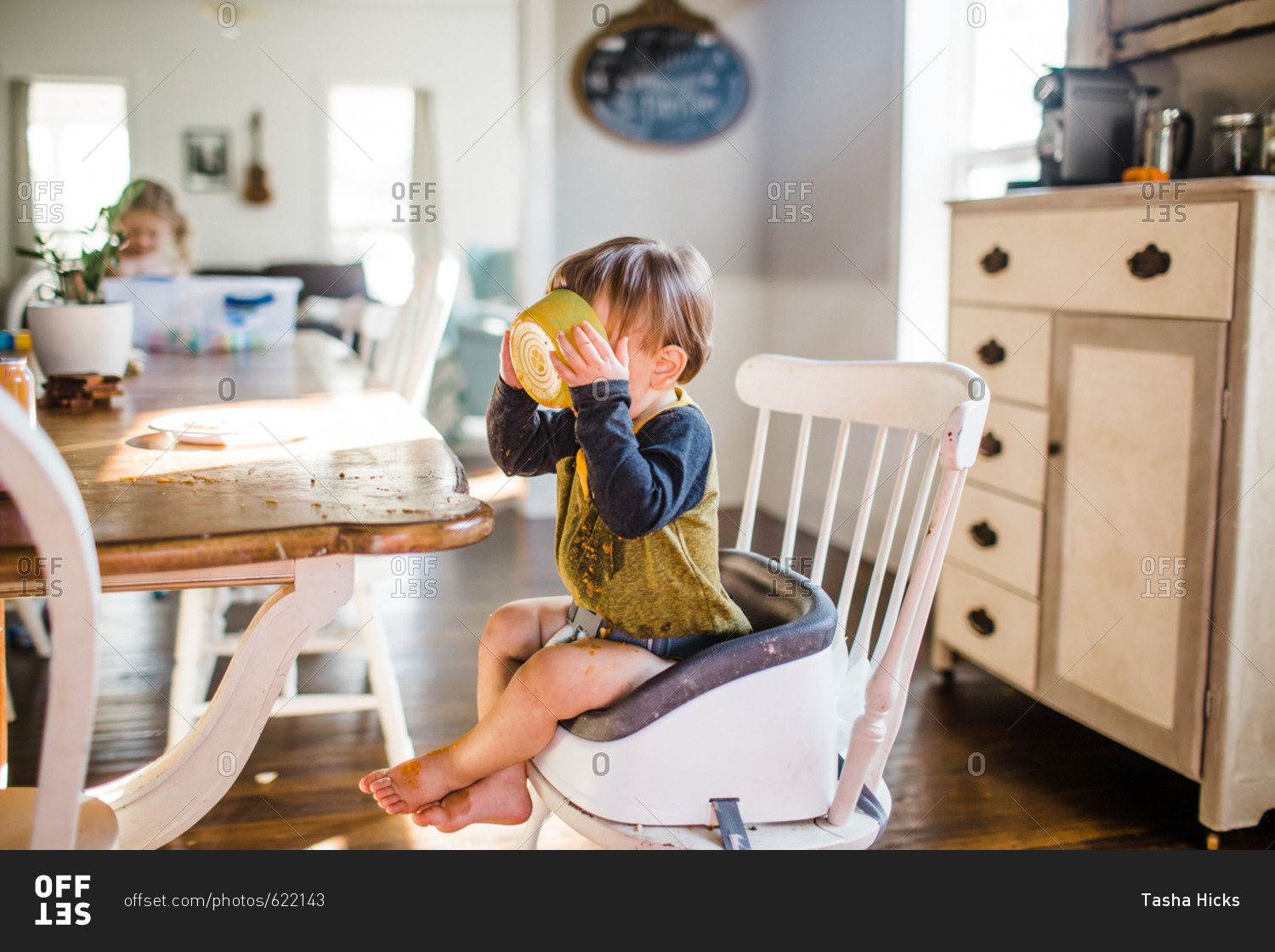 Toddler boy making mess while eating lunch stock photo - OFFSET