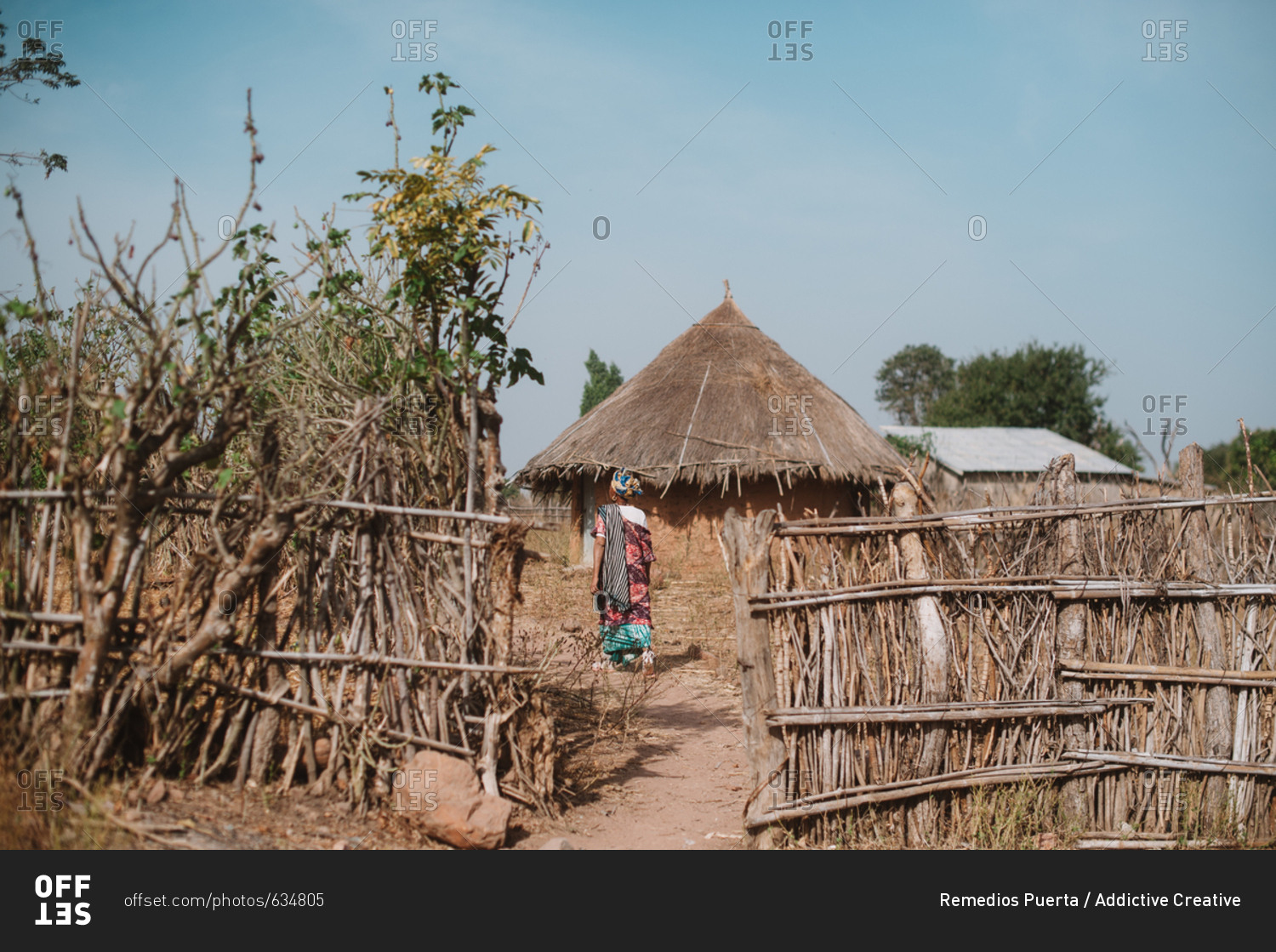 Exterior view of fence and thatched bungalows in native African village ...