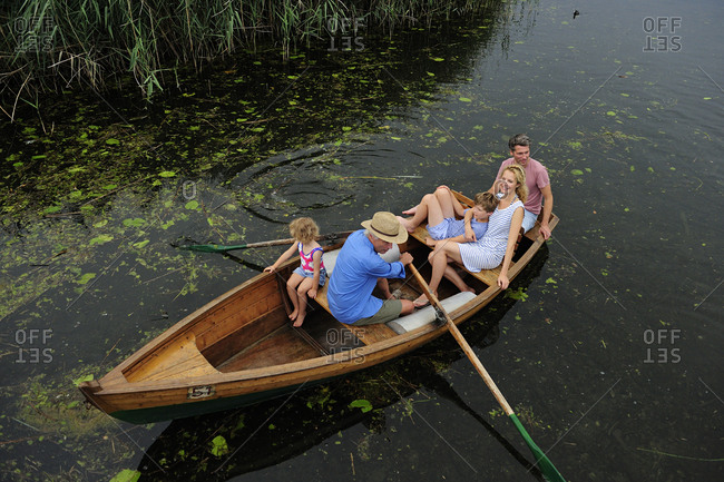 Family in rowing boat on lake stock photo - OFFSET