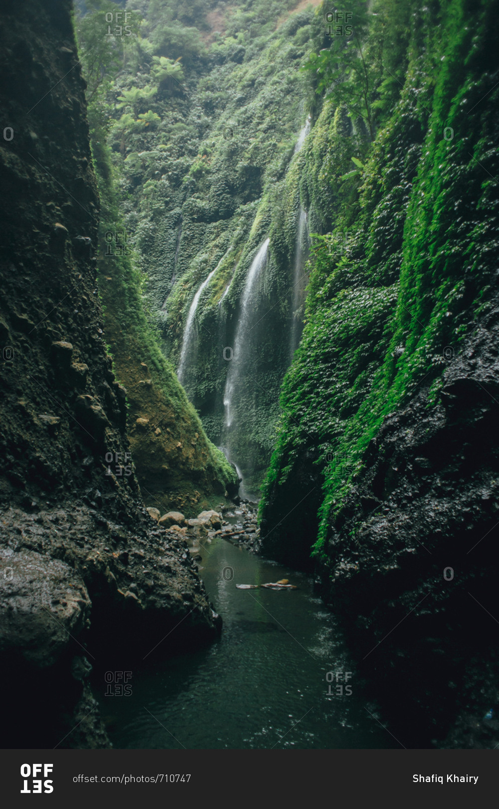 Waterfalls falling down the side of steep sided gorge into river stock ...