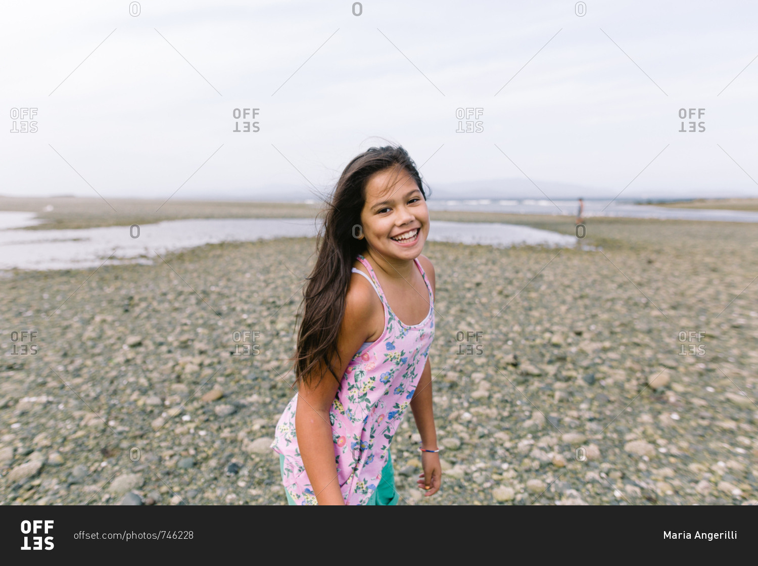 Smiling mixed race tween girl at the beach stock photo - OFFSET