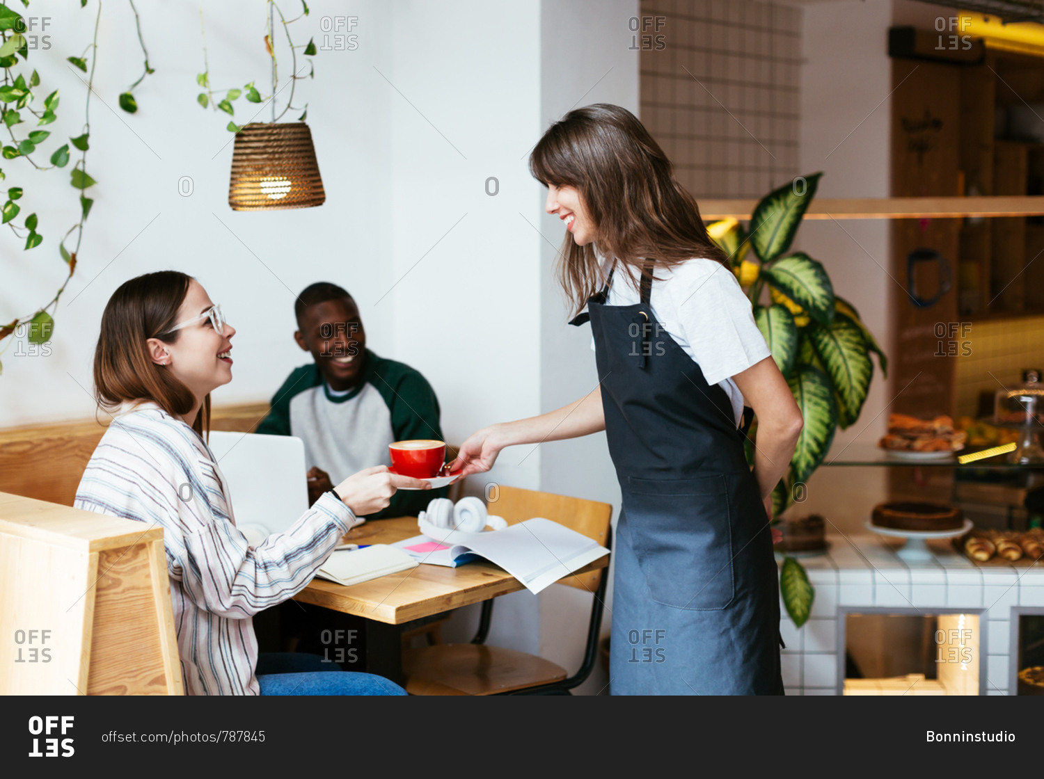 Waitress serving a coffee to customers in a coffee shop. stock photo ...