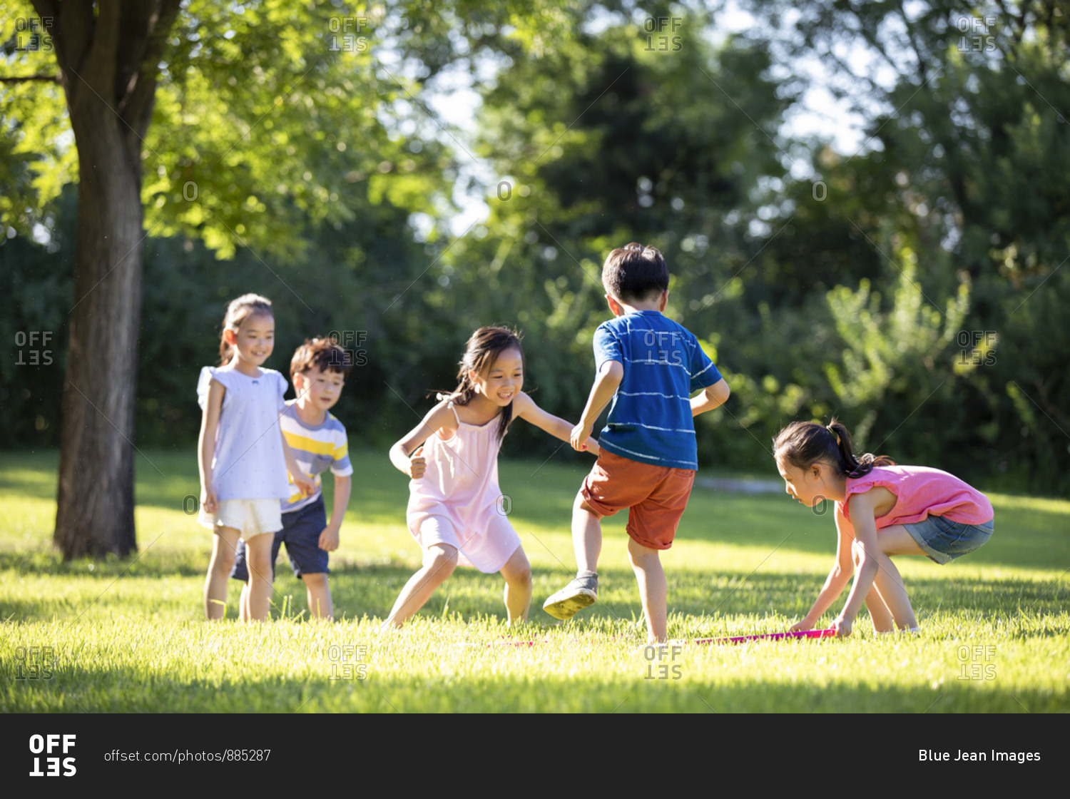 Happy Chinese children playing on meadow stock photo - OFFSET