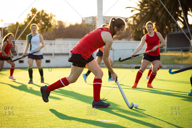 Side view of a Caucasian female field hockey player, during a field ...