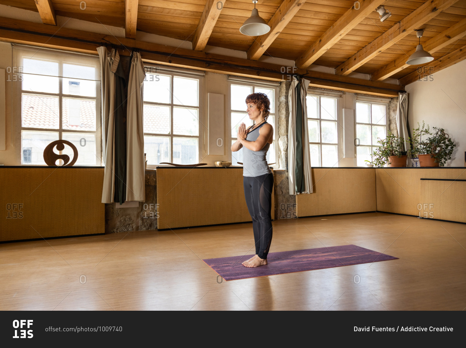 Full body side view of female standing in Mountain pose with namaste ...