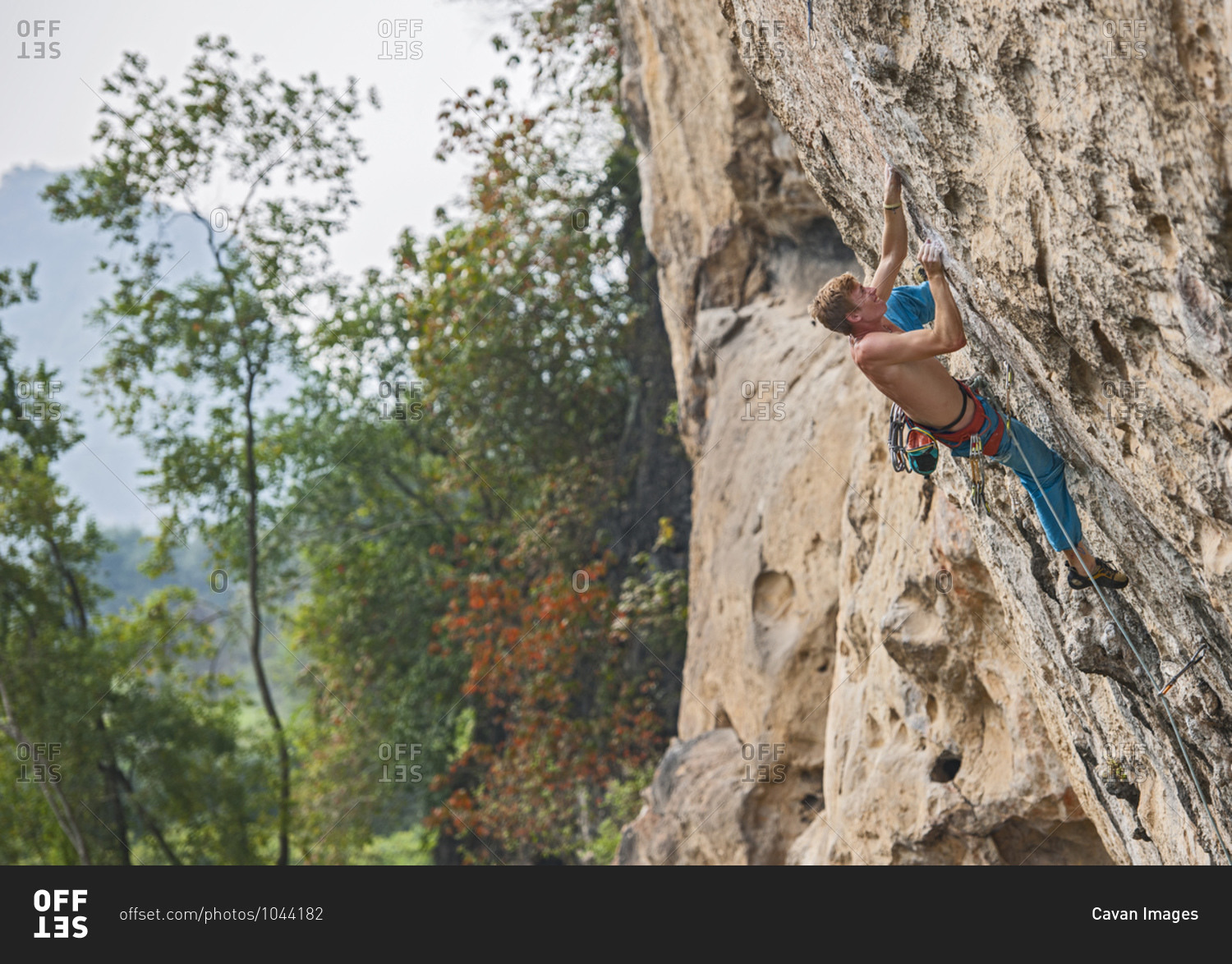 Man climbing on the limestone cliff "White Mountain" in Yangshuo ...