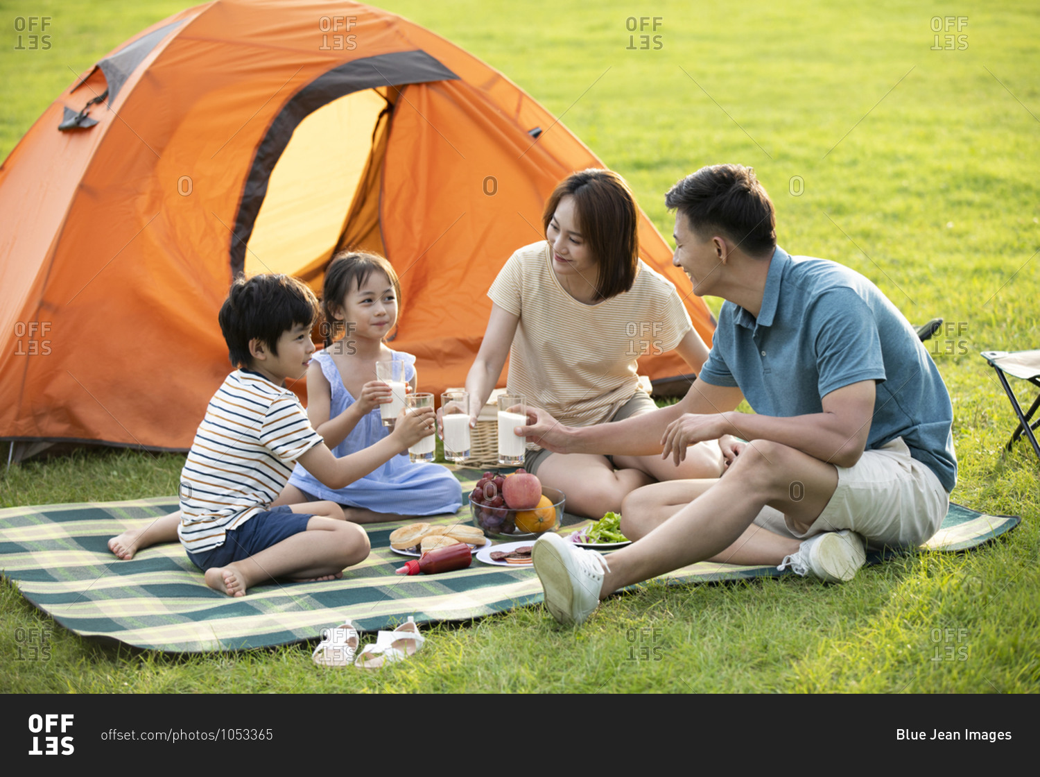 Happy young Chinese family having a picnic outdoors stock photo - OFFSET