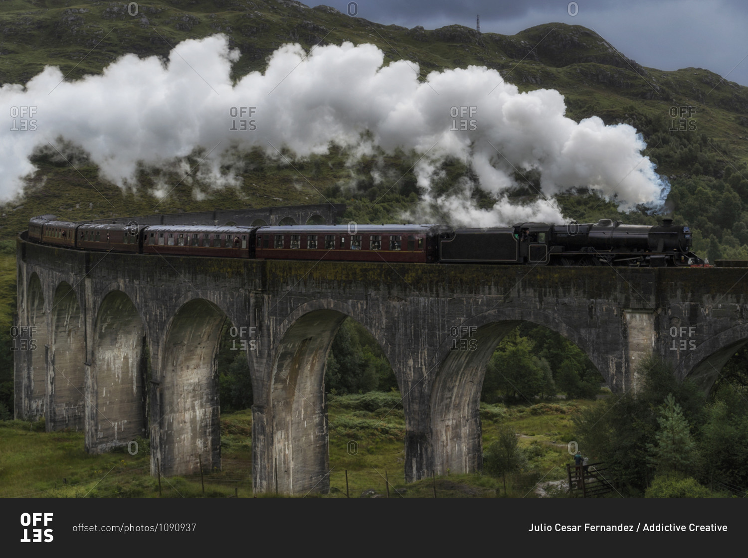 Old fashioned steam train riding along Glenfinnan Viaduct located in ...