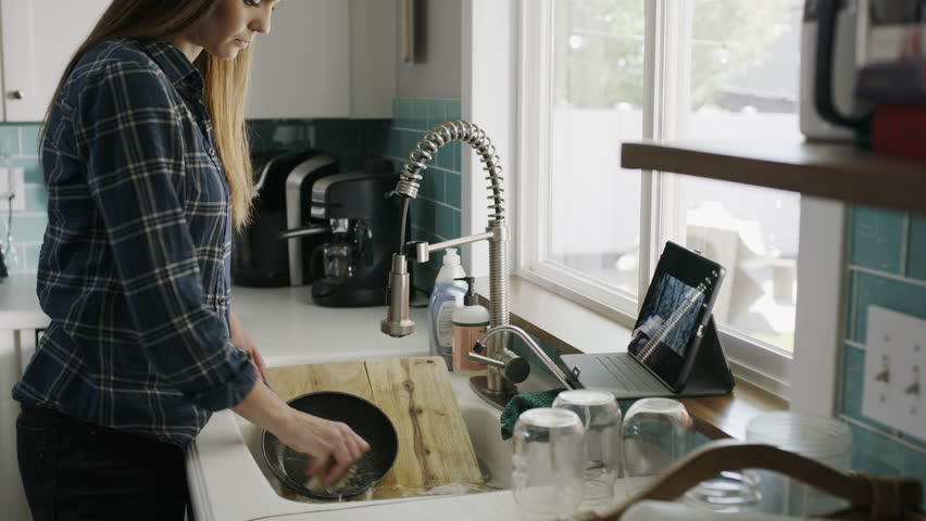 Woman Washing Dishes While Watching Stock Footage Video (100% Royalty ...