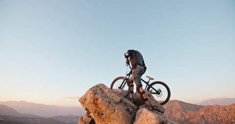 Cyclist Riding Bike Down Rock Sunrise Stock Photo (Edit Now) 1714931941